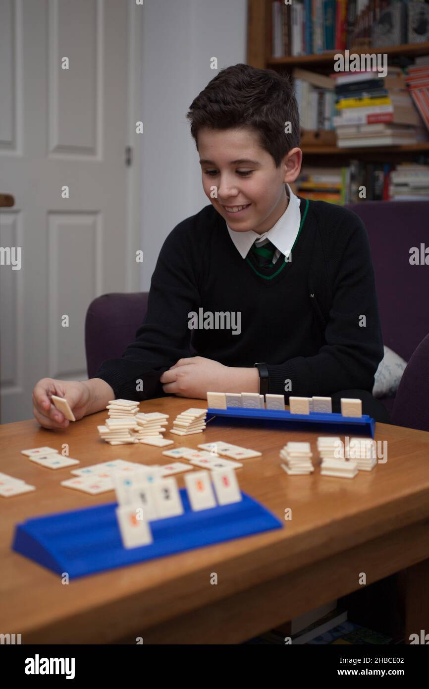 A boy playing Rummikub and laying down a tile Stock Photo - Alamy