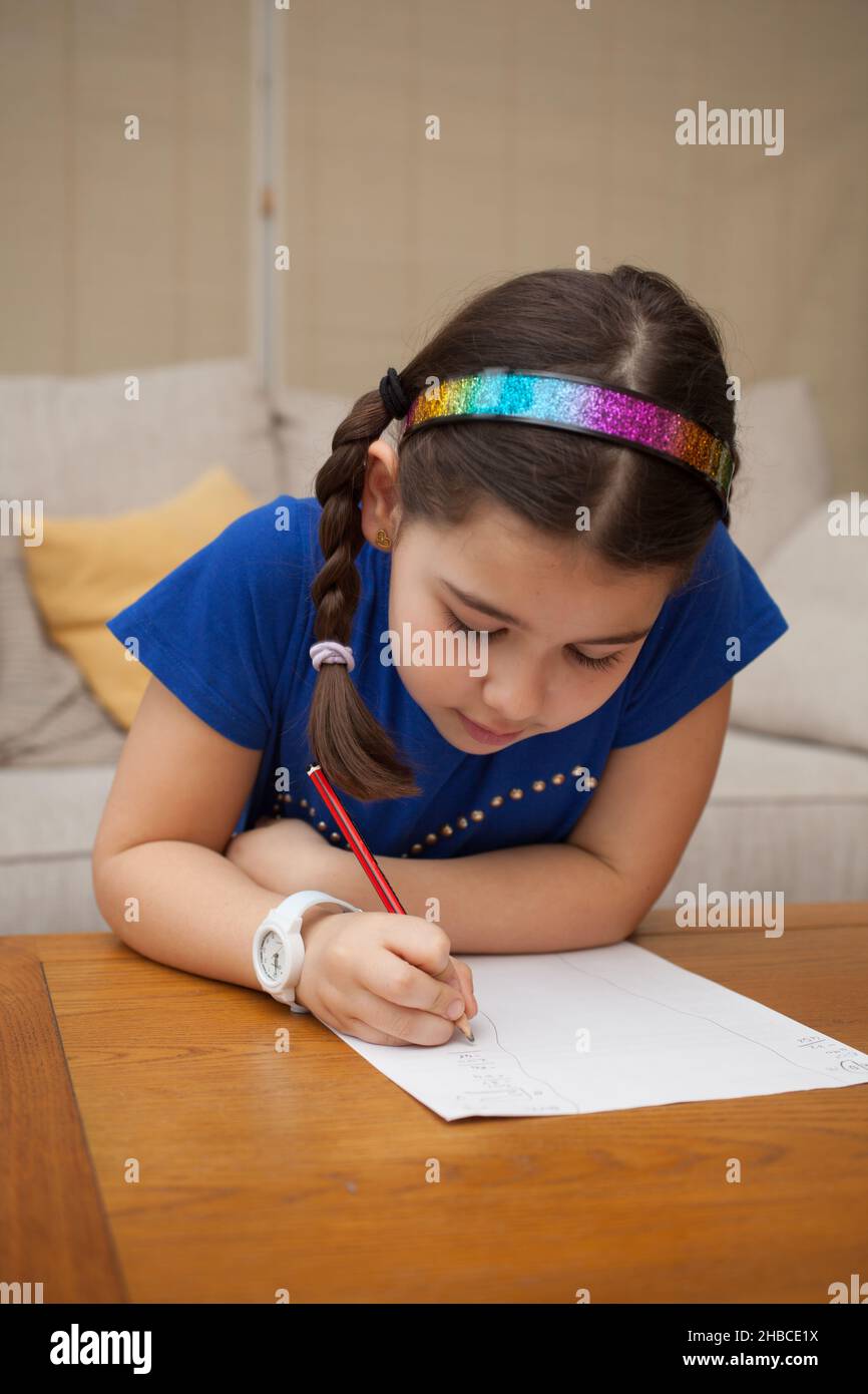 A girl at home writing notes on a piece of paper Stock Photo - Alamy