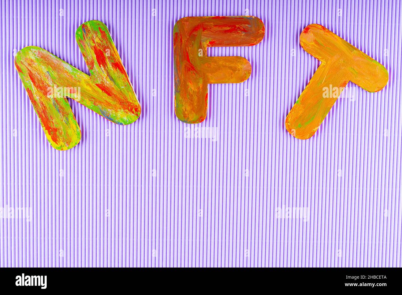 Non fungible token. NFT inscription of multicolored letters on a purple ...