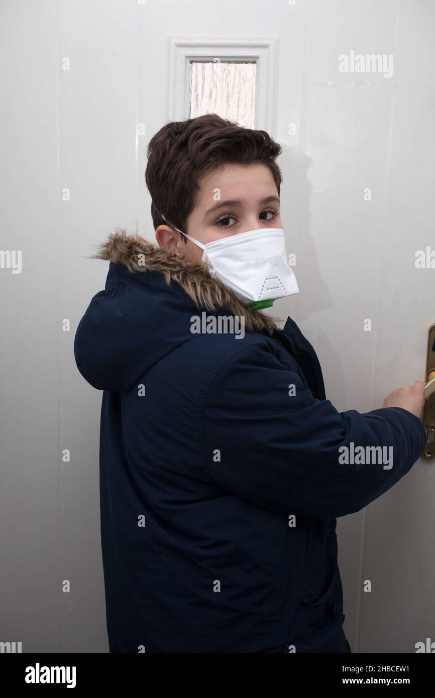 A school boy returning home with a face mask ask to protect against ...