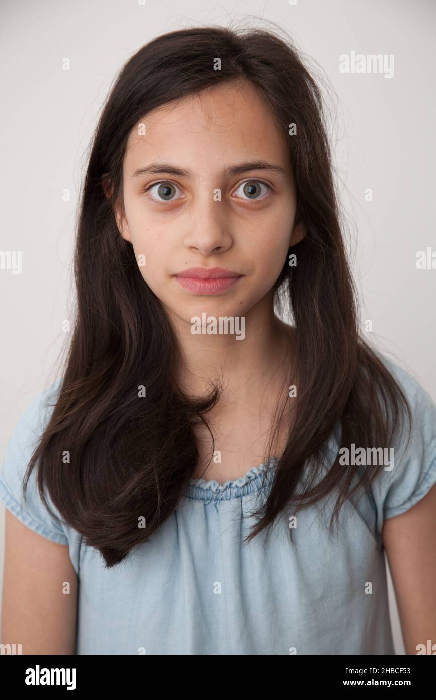 A portrait of a ten year old girl with a piercing stare of mixed race ...