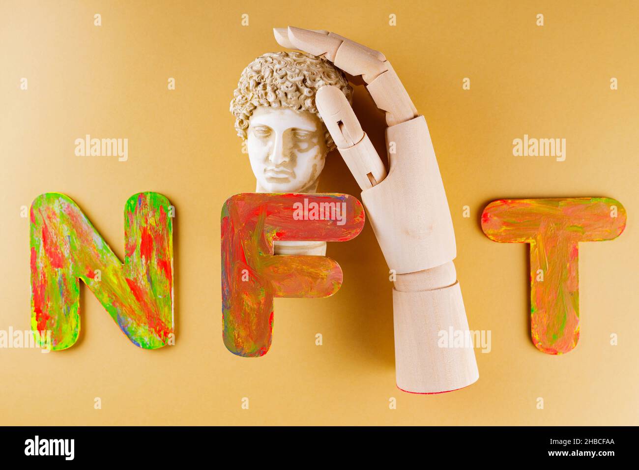 NFT (Non-Fungible token). Artificial fingers hug the plaster head of Hermes. NFT inscription on ...