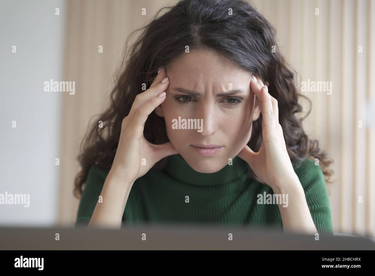 Concerned young italian woman employee looking at computer screen with ...