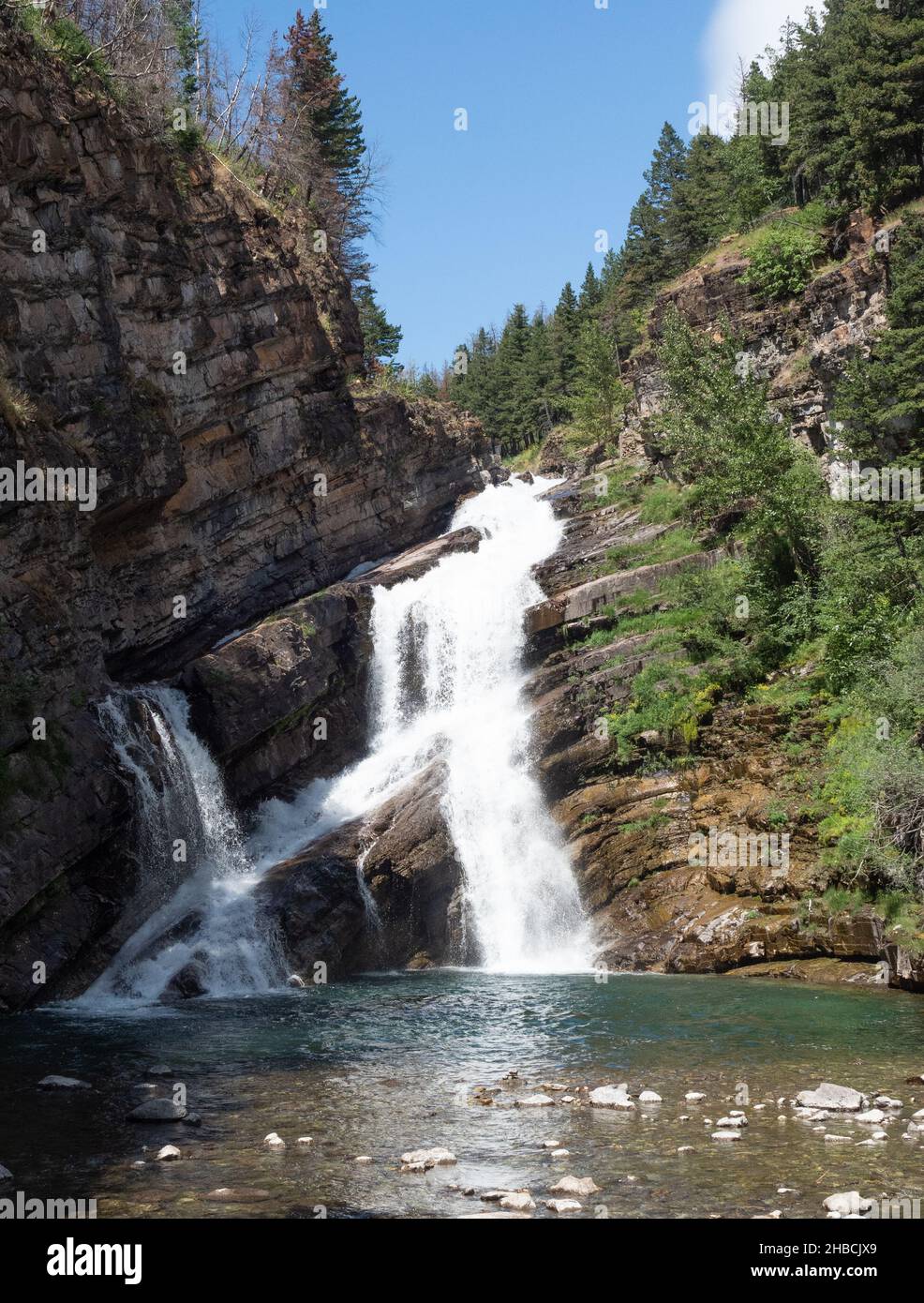 Cameron Falls pouring over rocky cliff at the edge of Waterton Village ...