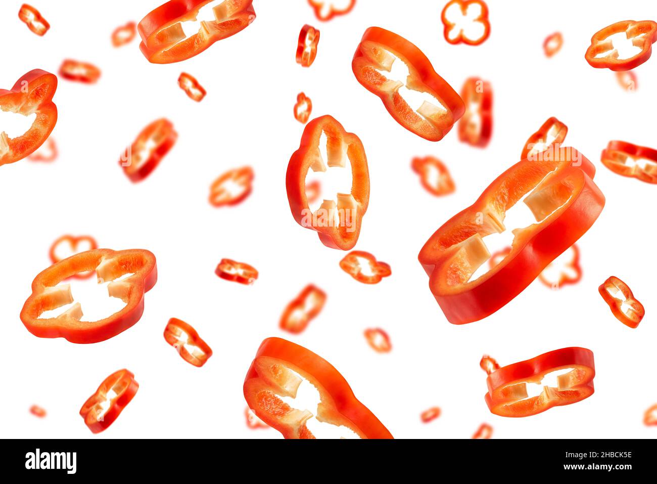 Red bell pepper cut into slices isolated on white background. Falling ...