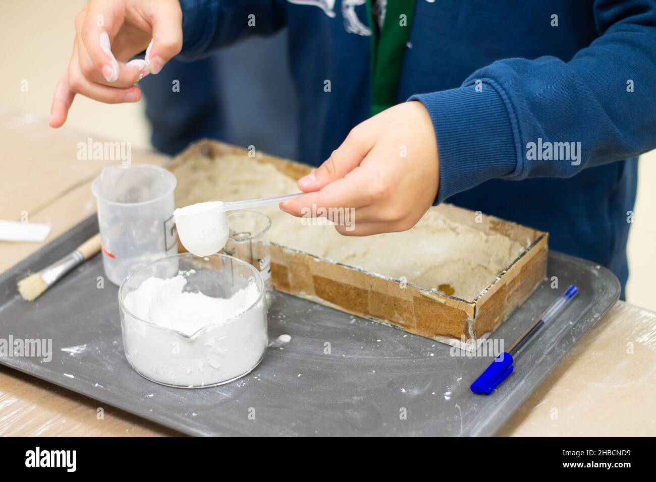 Child's hands are preparing a plaster mix in the laboratory for ...