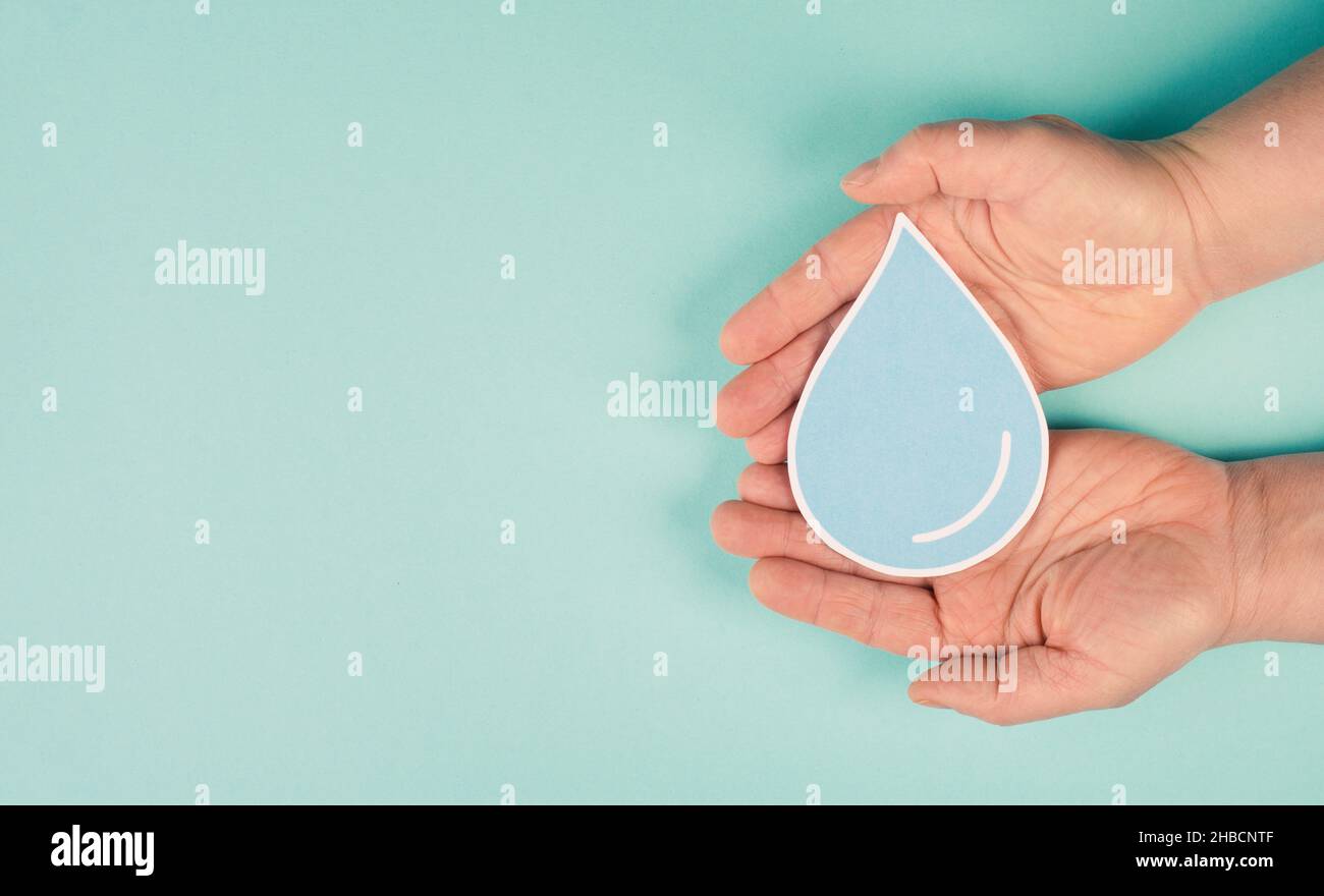 Hands holding a drop of water, paper cut out, environmental issue, copy ...