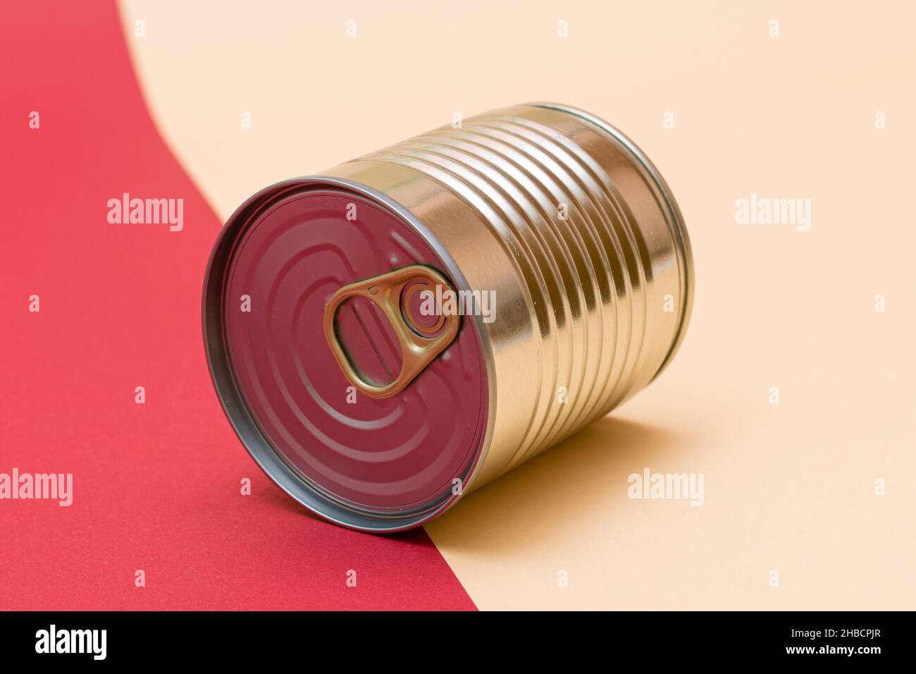Unopened Tin Can with Blank Edge on Split Red and Beige Background ...