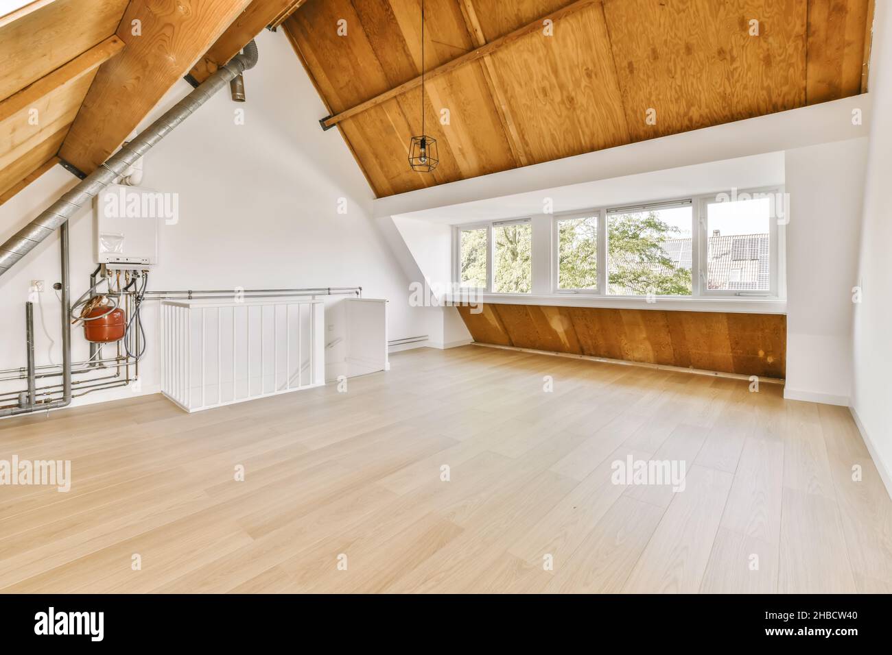 Lovely attic room with wood ceiling and parquet floor Stock Photo - Alamy
