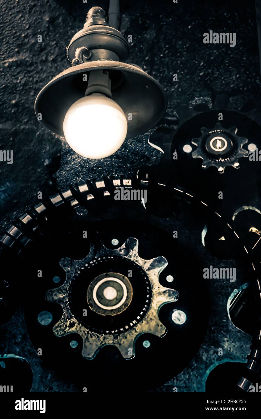 Light bulb and gears against a dark background - Blue tone Stock Photo ...