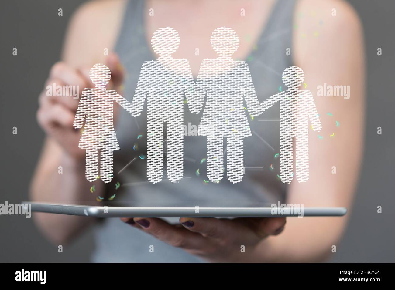 A hologram of a family floating on the tablet being held by a person ...