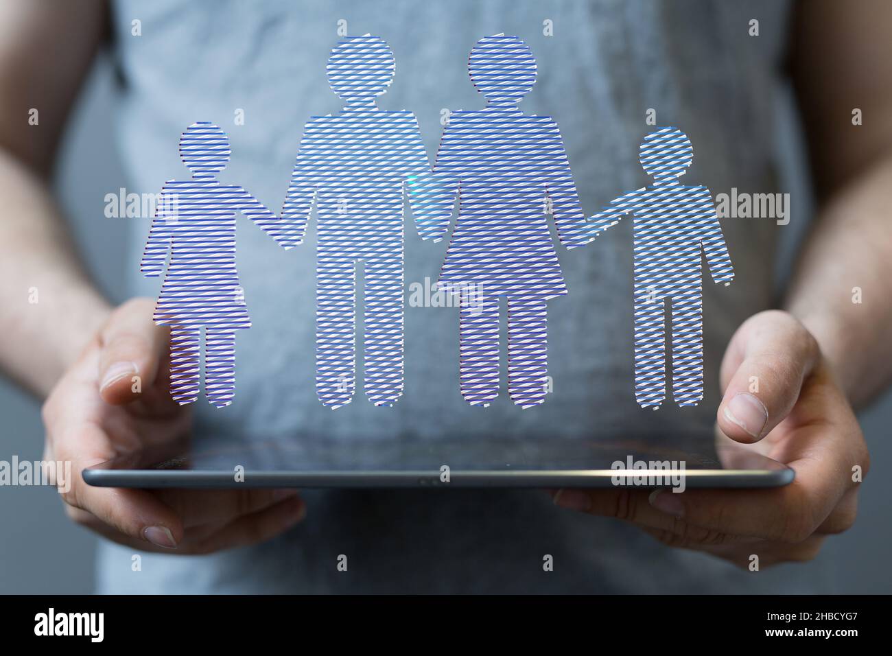 A hologram of a family floating on the tablet being held by a person ...