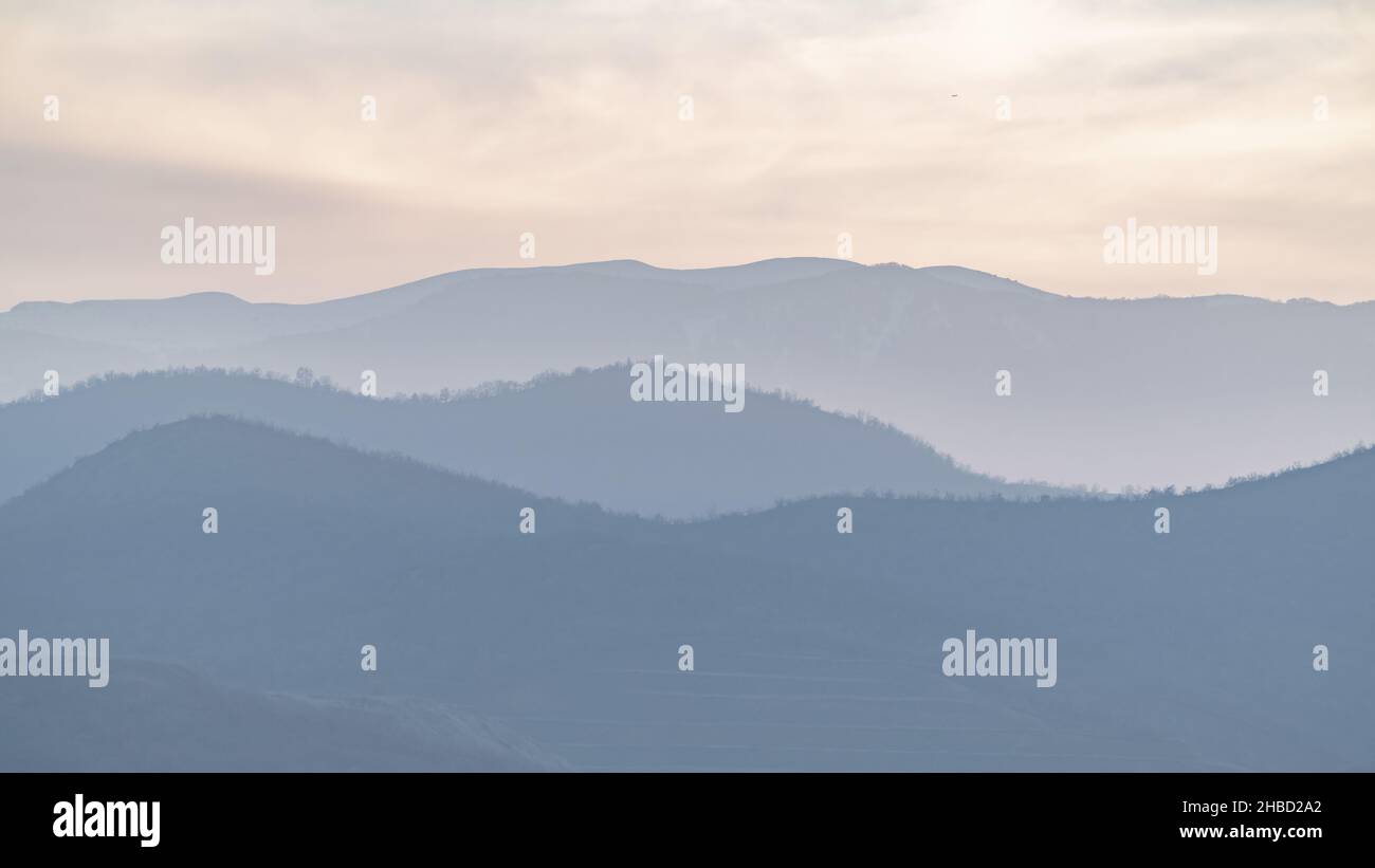 Silhouettes of mountains in the sunset haze Stock Photo - Alamy