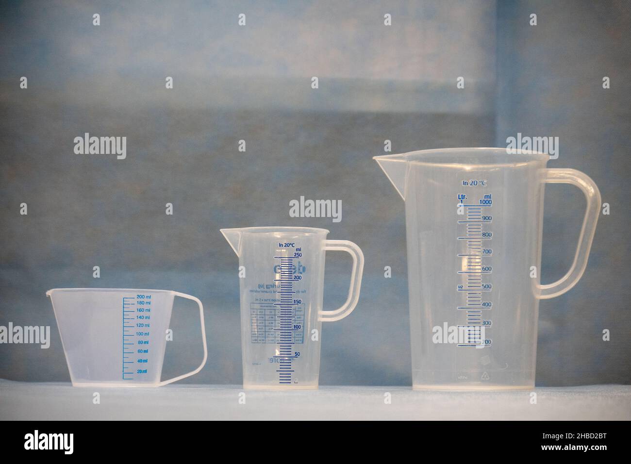 3 white measuring cups of different sizes stand next to each other ...