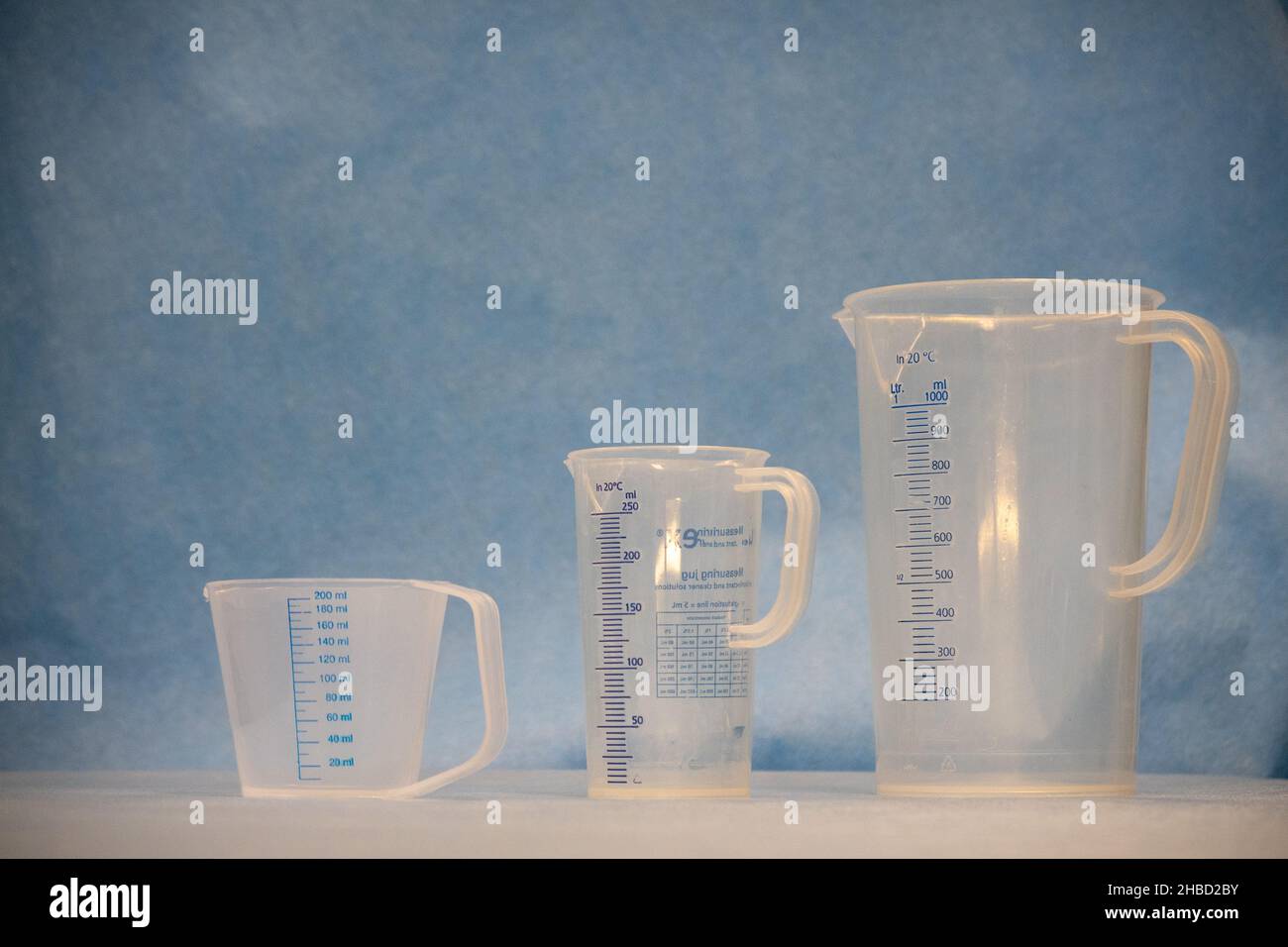 3 white measuring cups of different sizes stand next to each other ...
