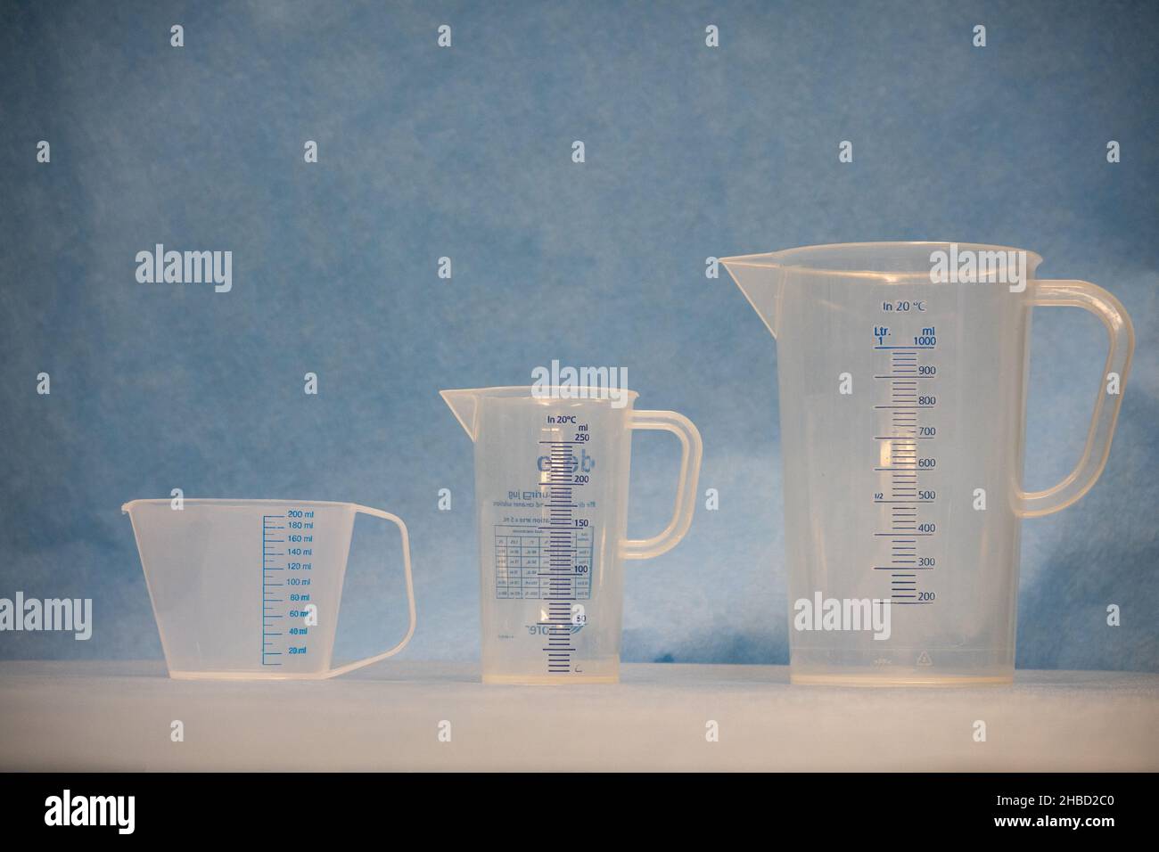 3 white measuring cups of different sizes stand next to each other ...