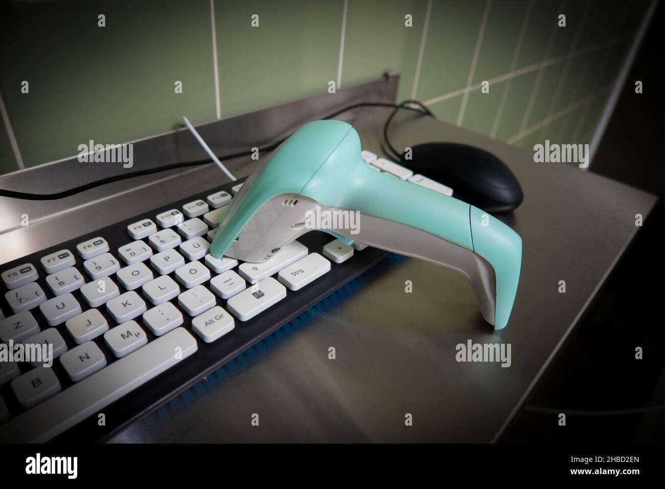 next to one black computer keyboard is a green barcode scanner Stock ...