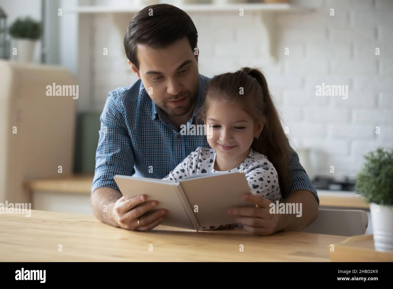 Caring Caucasian father with 9s daughter reading book together Stock ...