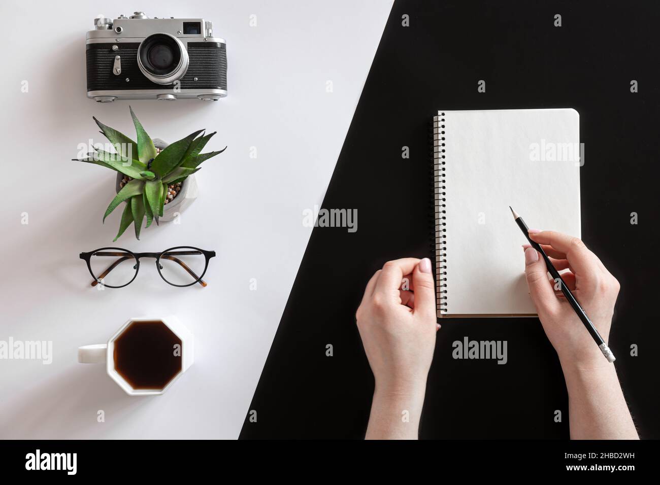 Flat lay composition with hands and blank notepad on black and white ...