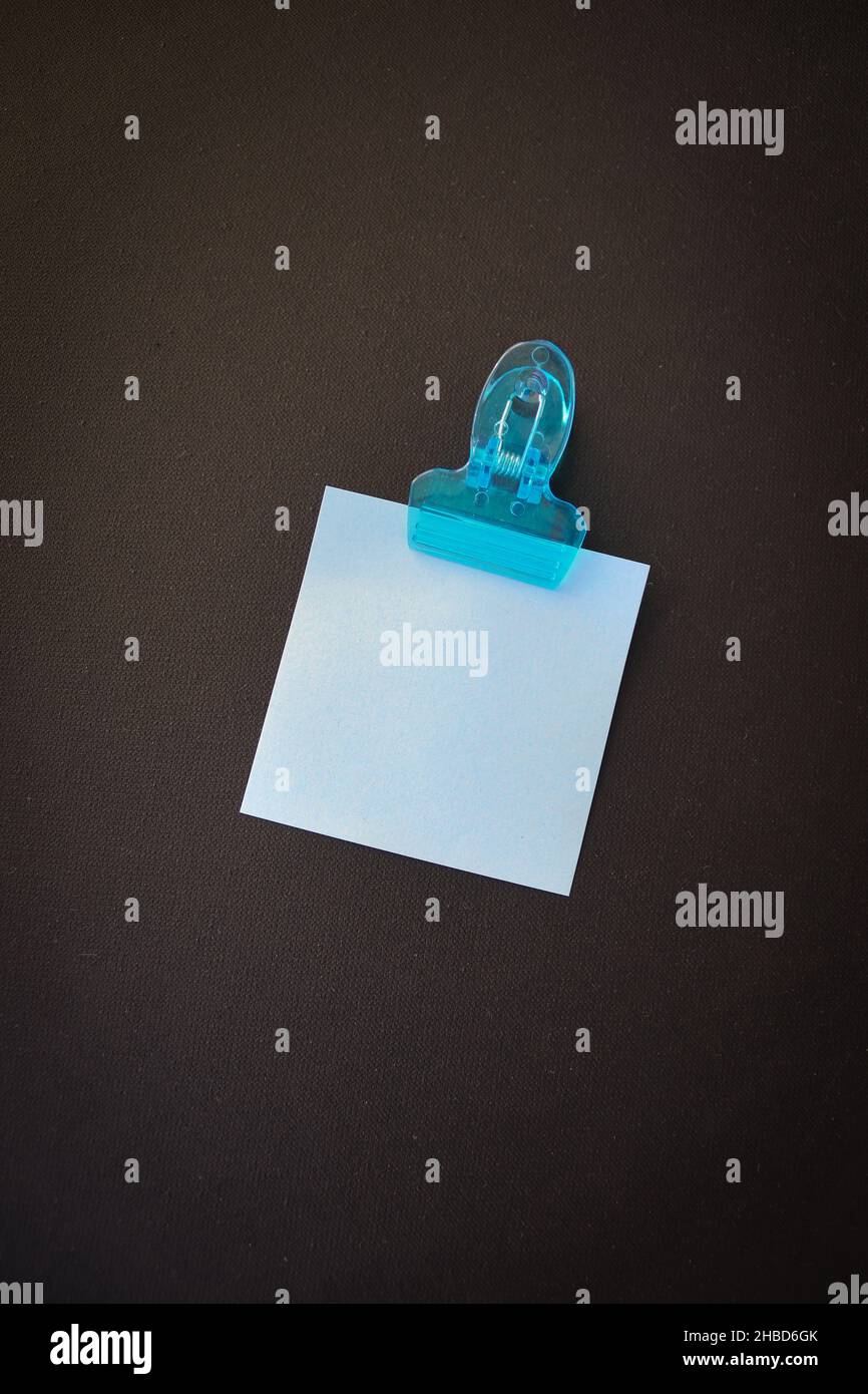 Post it note with clip on dark background Stock Photo - Alamy