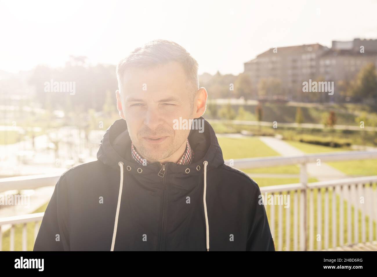 Happy man portrait illuminated by sunlight beams in cityscape ...