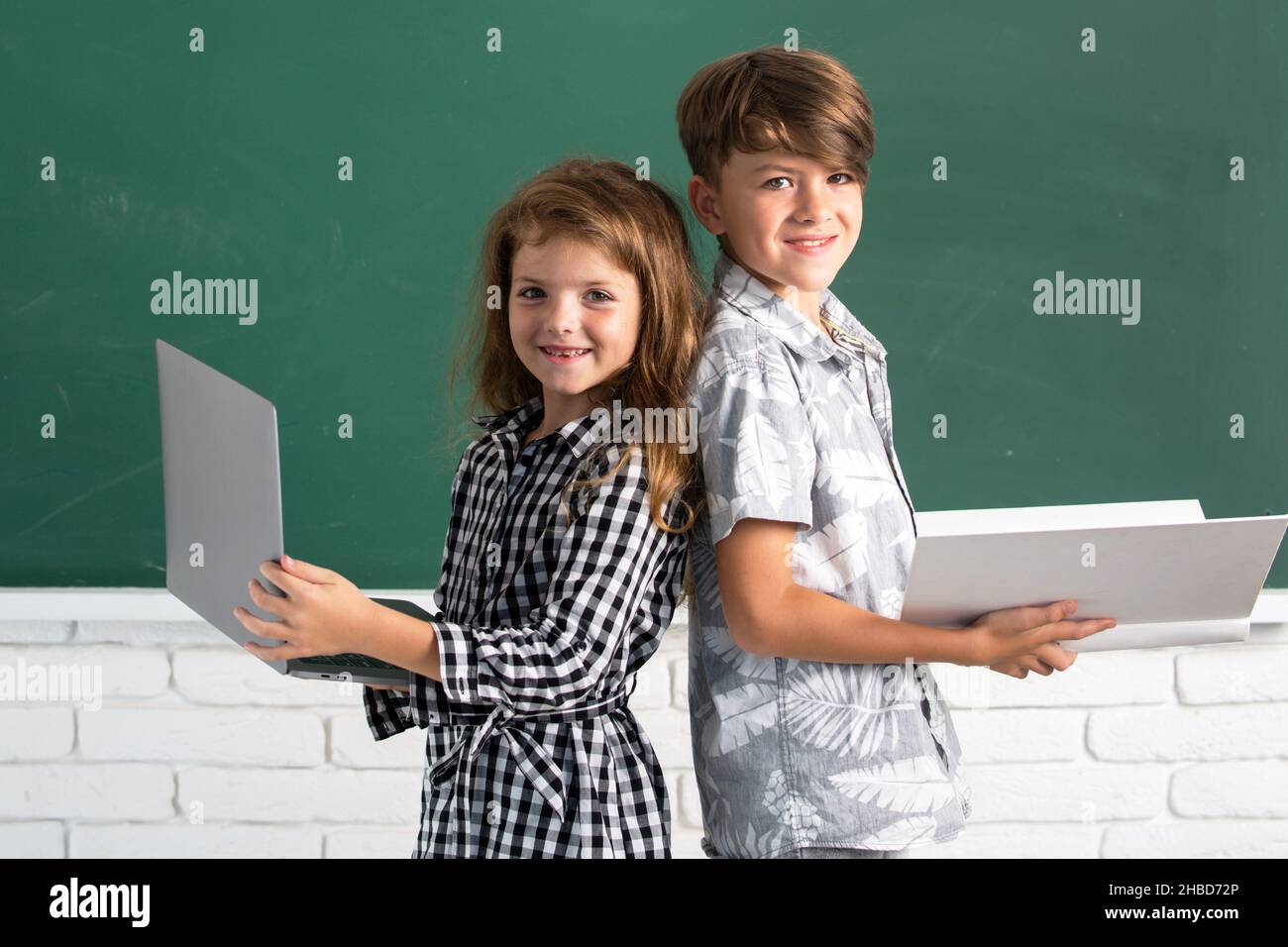 Elementary school kids. Portrait of children boy and girl with laptop ...