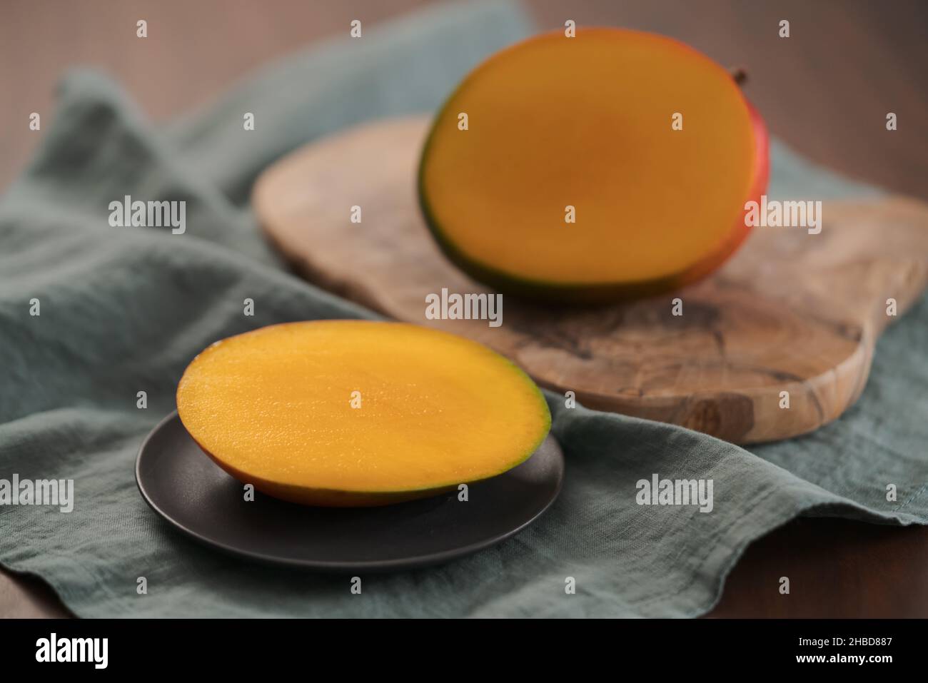 Freshly cut ripe mango on olive board, shallow focus Stock Photo - Alamy