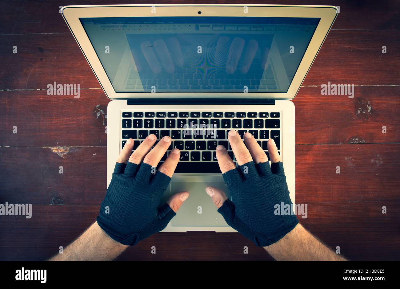 look down to the males hands with gloves typing on laptop keyboard on ...