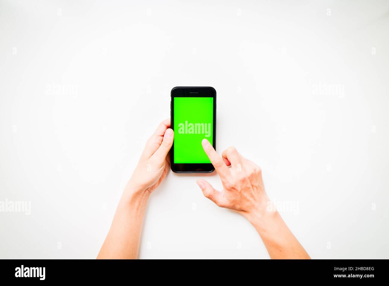 Females hand shows mobile smartphone with green screen in vertical ...