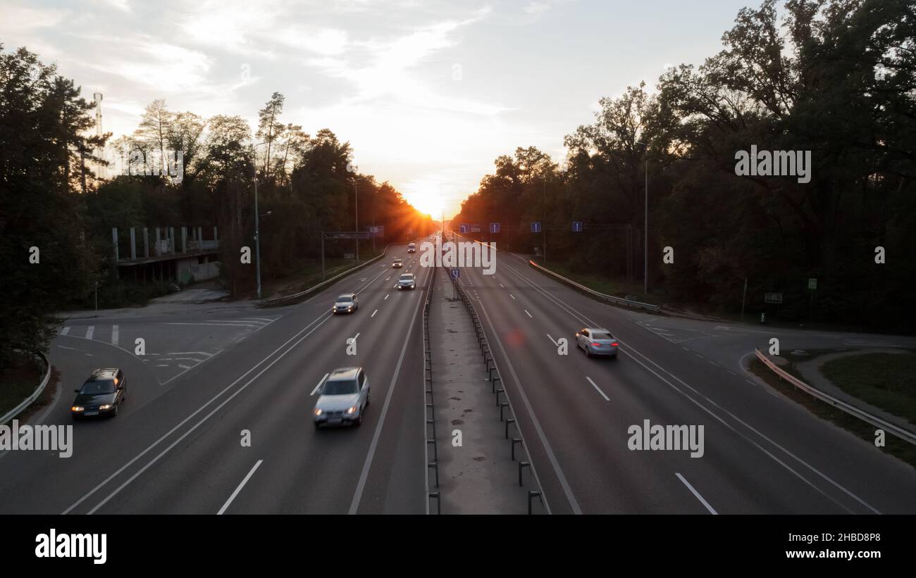 Moving cars on the motorway at sunset time. Highway traffic at sunset ...
