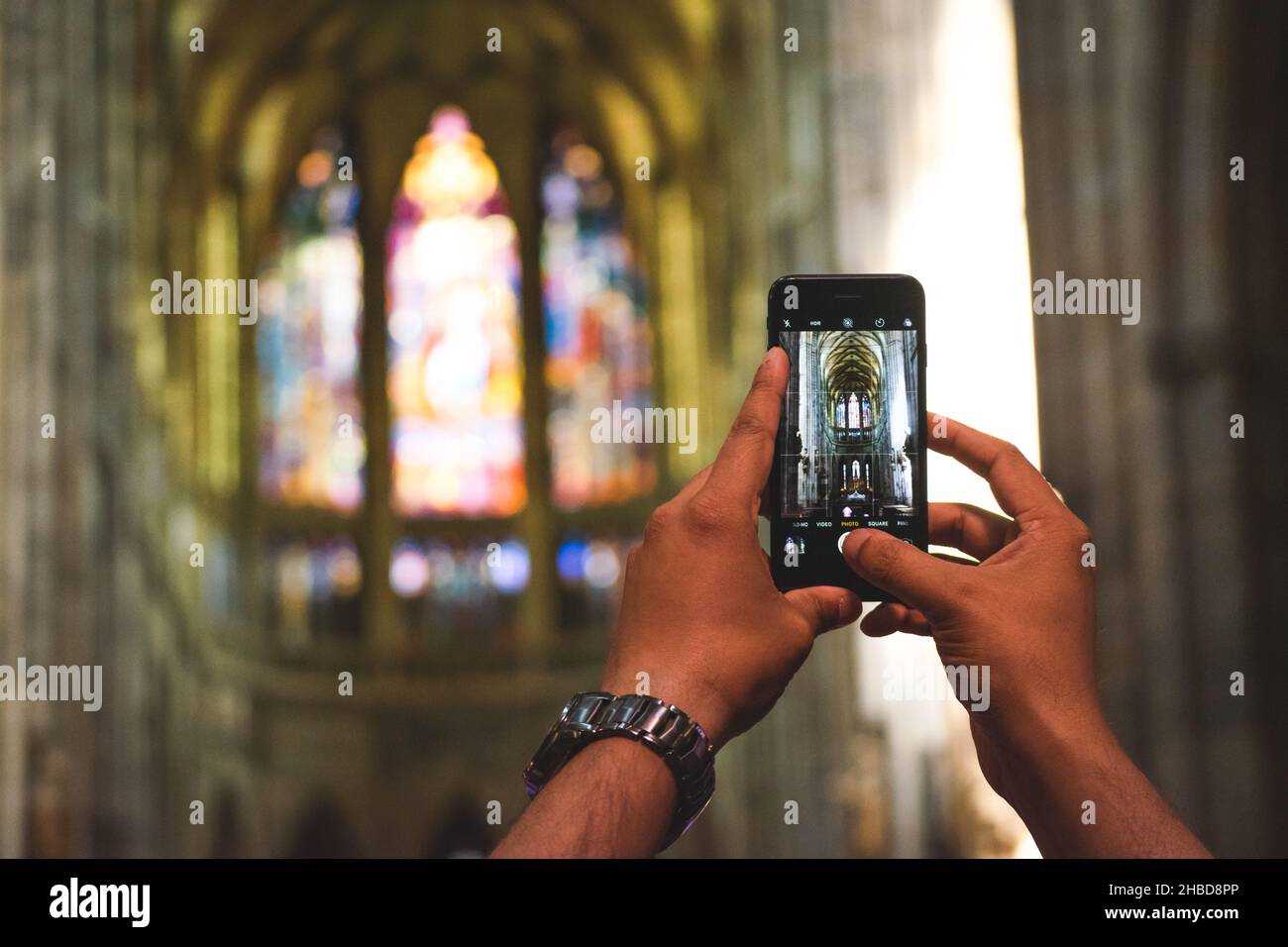 hands holding a mobile phone directed to the window in a church Stock ...