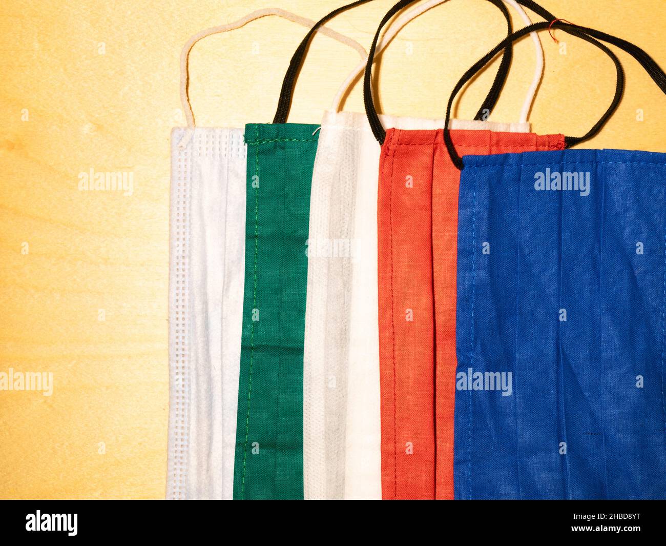 Close up of Five different colors MAsks laying on the wooden surface ...