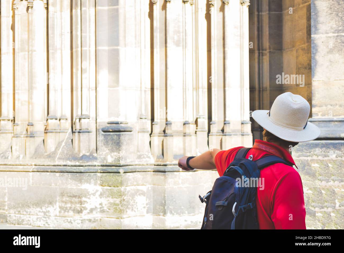 Male guide person in red is showing elements of historical landmarks in ...