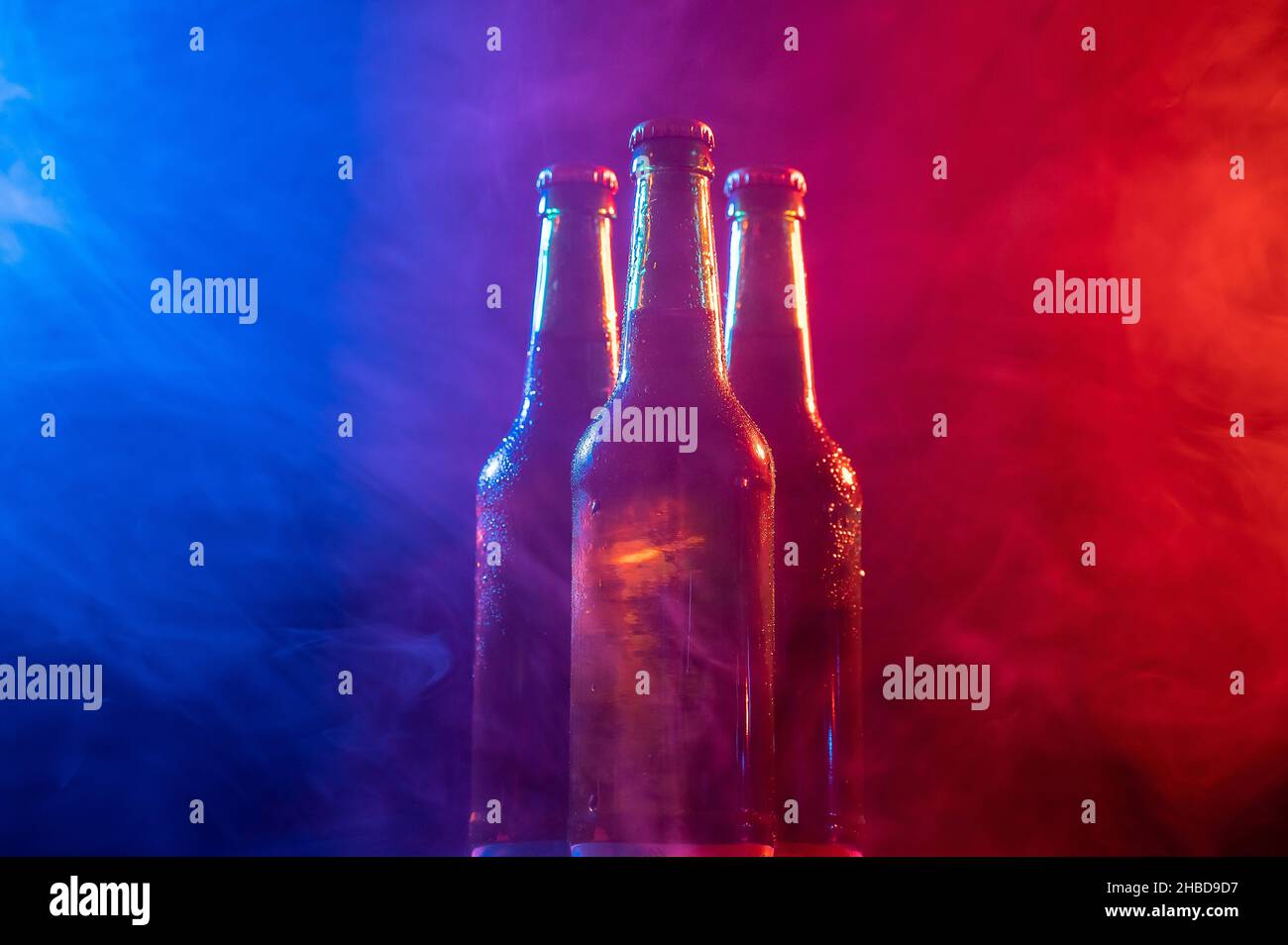 Three bottles of beer in a blue-pink mist Stock Photo - Alamy
