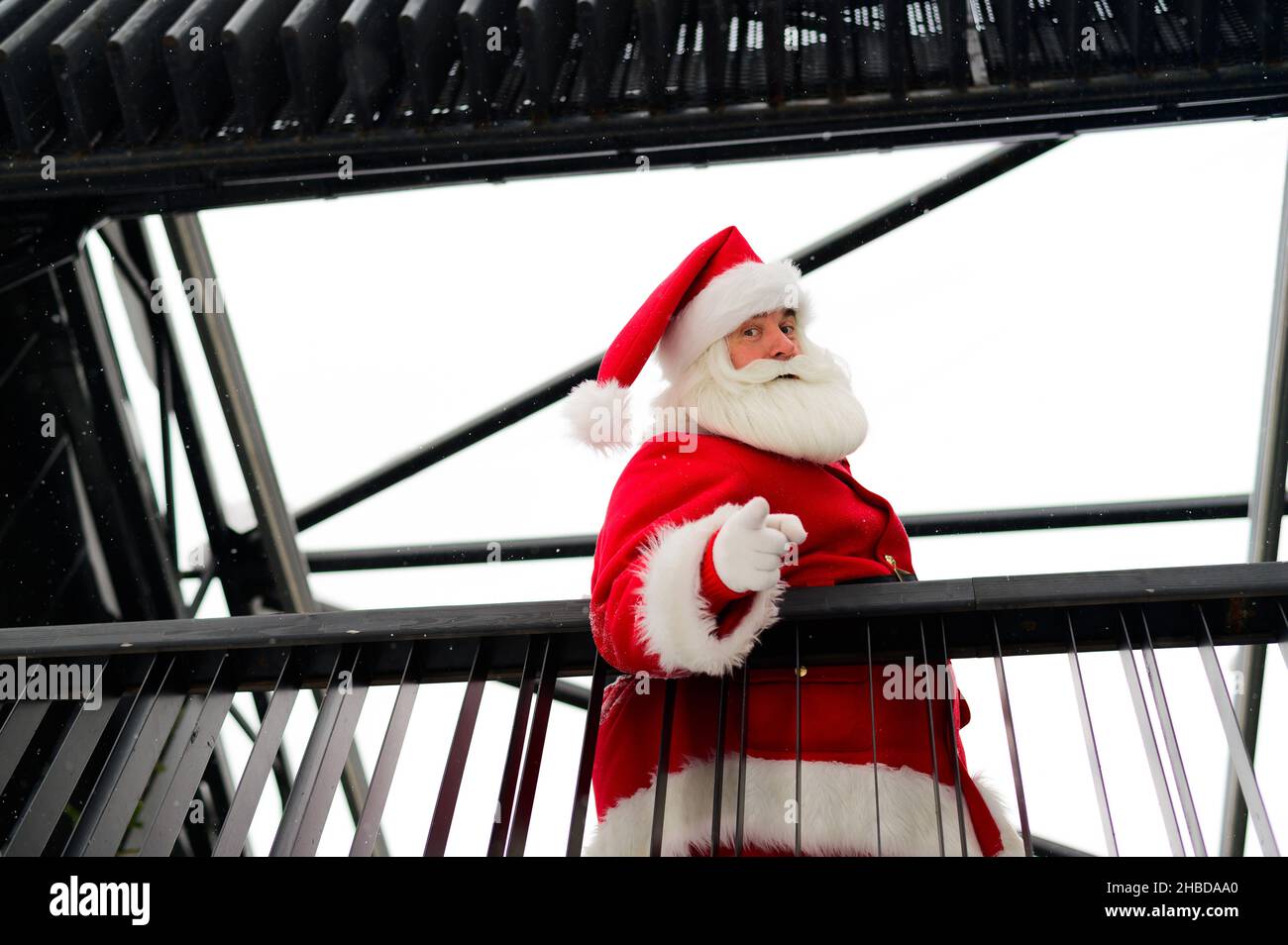 Santa claus looks down from the stairs and wishes a merry christmas ...