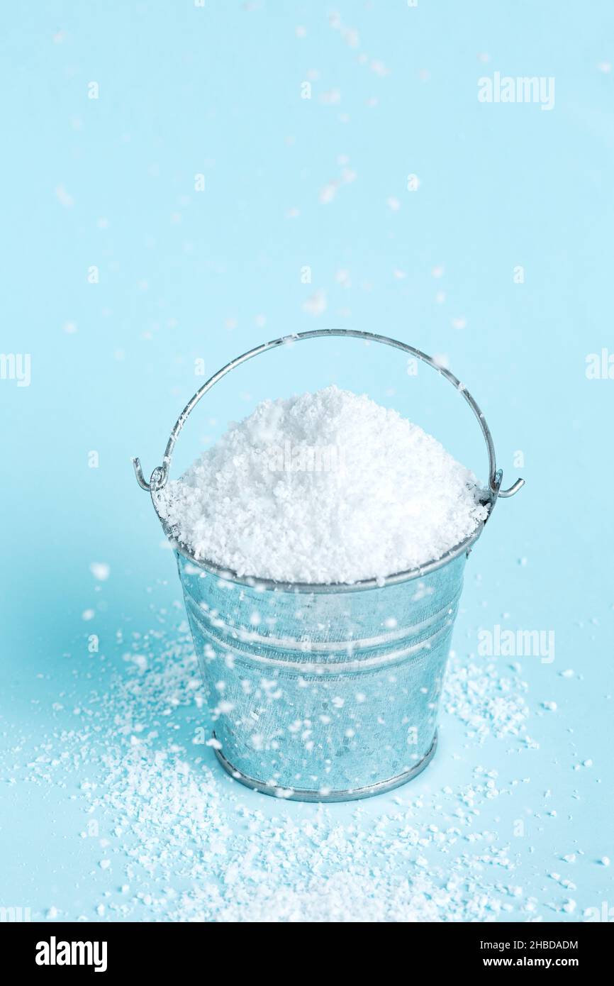 Bucket with snow on a blue background. Snowflakes fly Stock Photo - Alamy