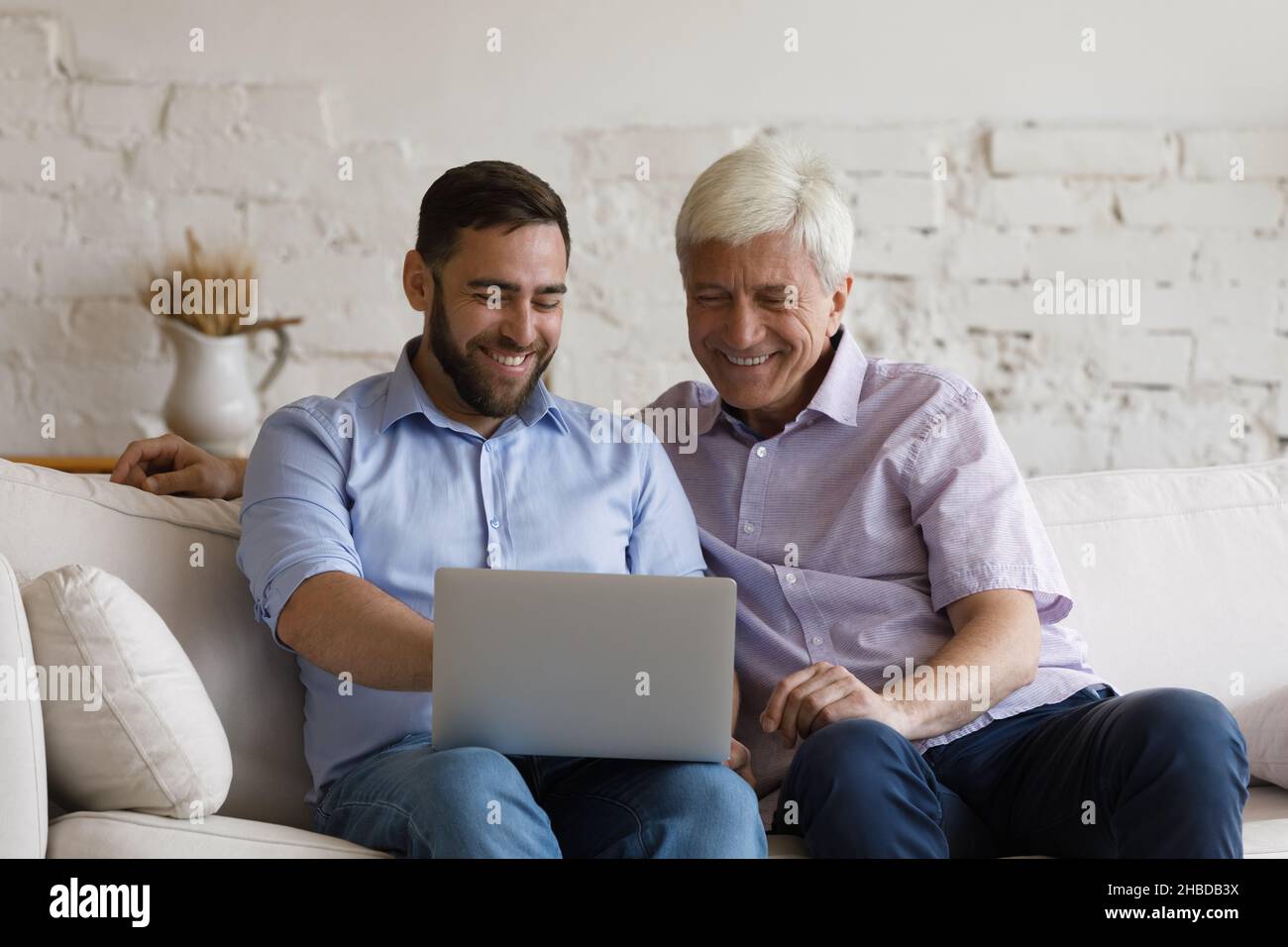 Happy young man using computer with old father Stock Photo - Alamy