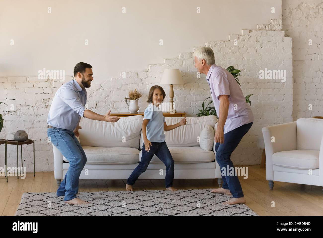 Happy three male generations family dancing at home Stock Photo - Alamy
