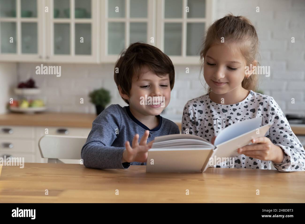 Cute little boy and girl reading fairy tale book together Stock Photo ...