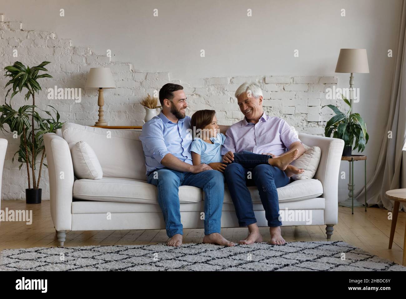Happy three generations family talking at home Stock Photo - Alamy