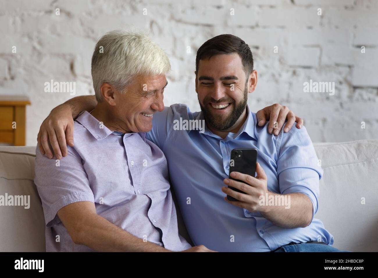 Happy bonding two male generations family using cellphone Stock Photo ...
