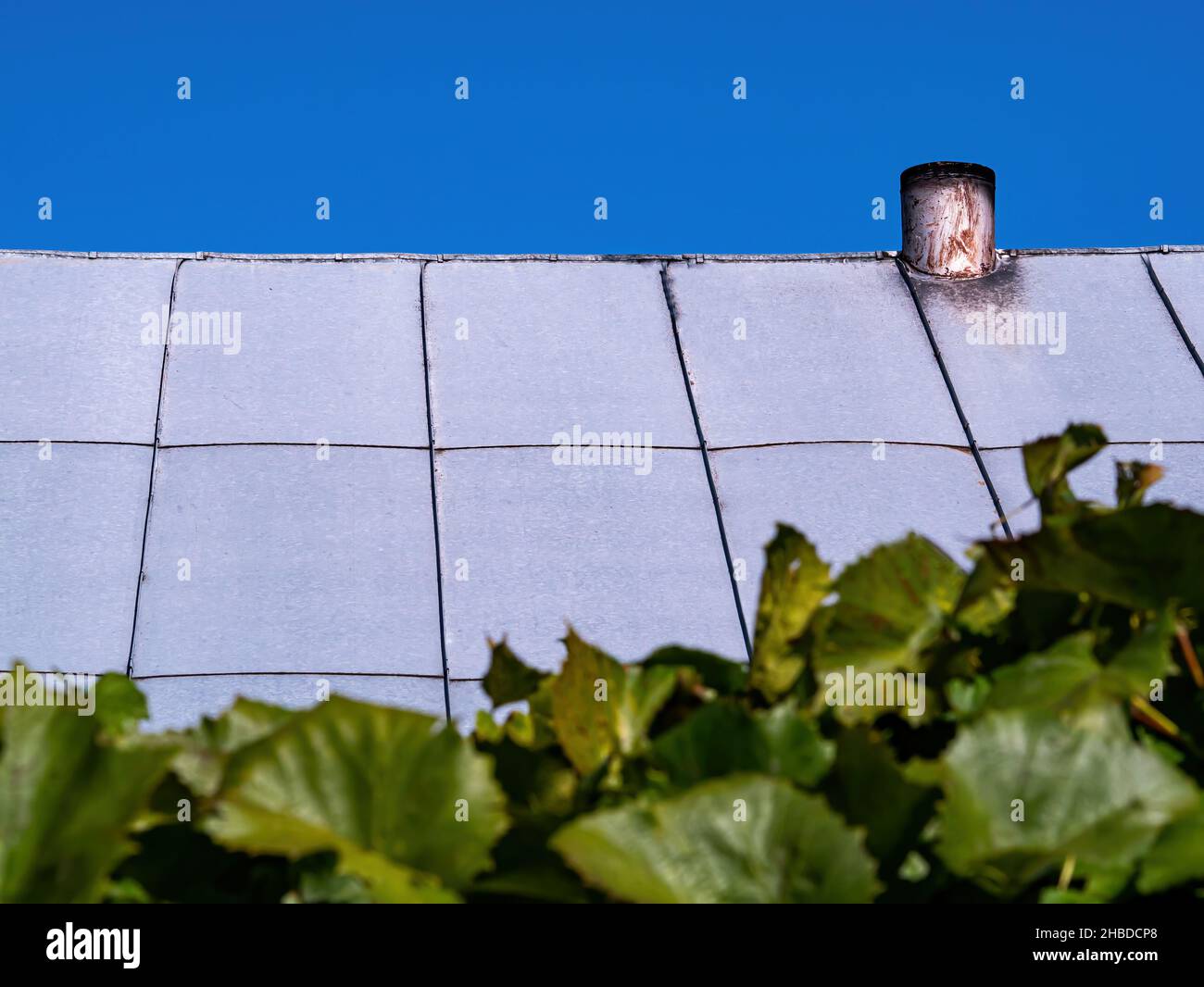 Iron roof of a wooden house with a chimney Stock Photo - Alamy
