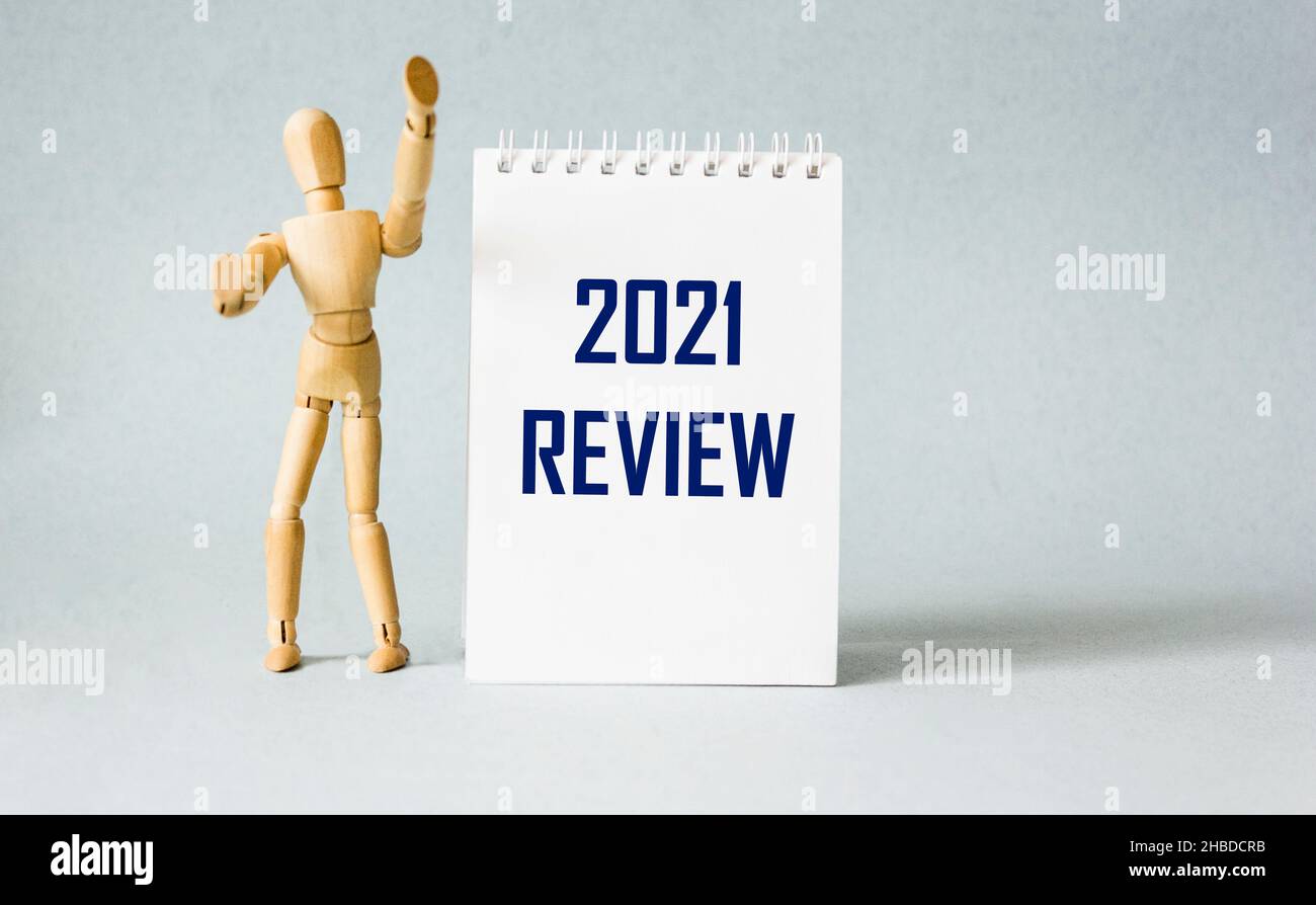 2021 review text on notepad with wooden doll, year end business concept ...