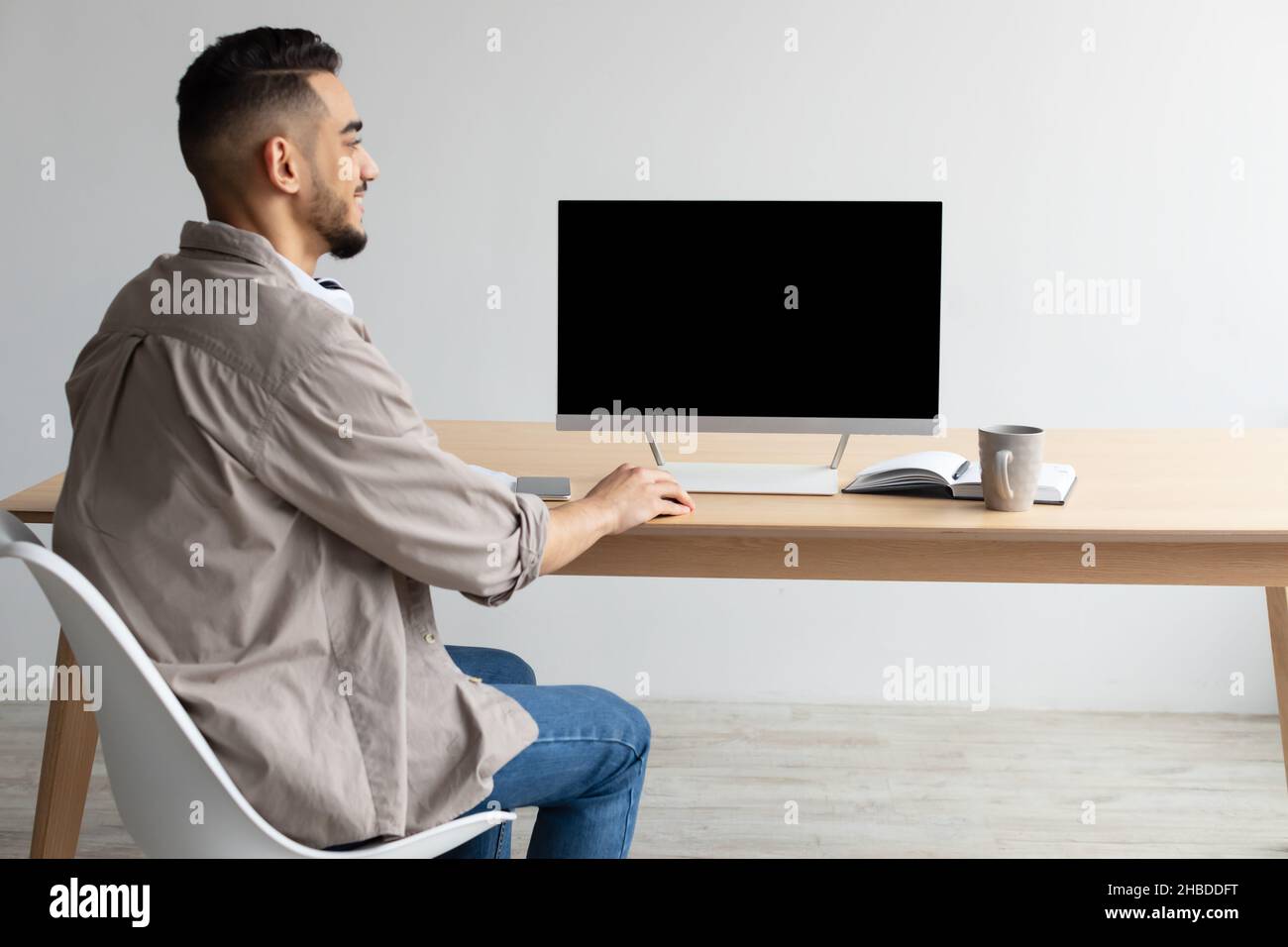 Arab man looking at blank empty computer monitor Stock Photo - Alamy