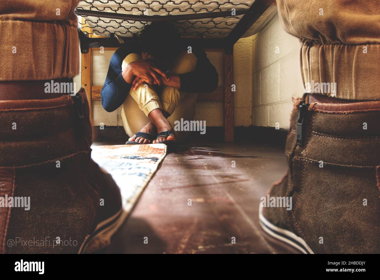 A person crying hiding under a bed Stock Photo - Alamy