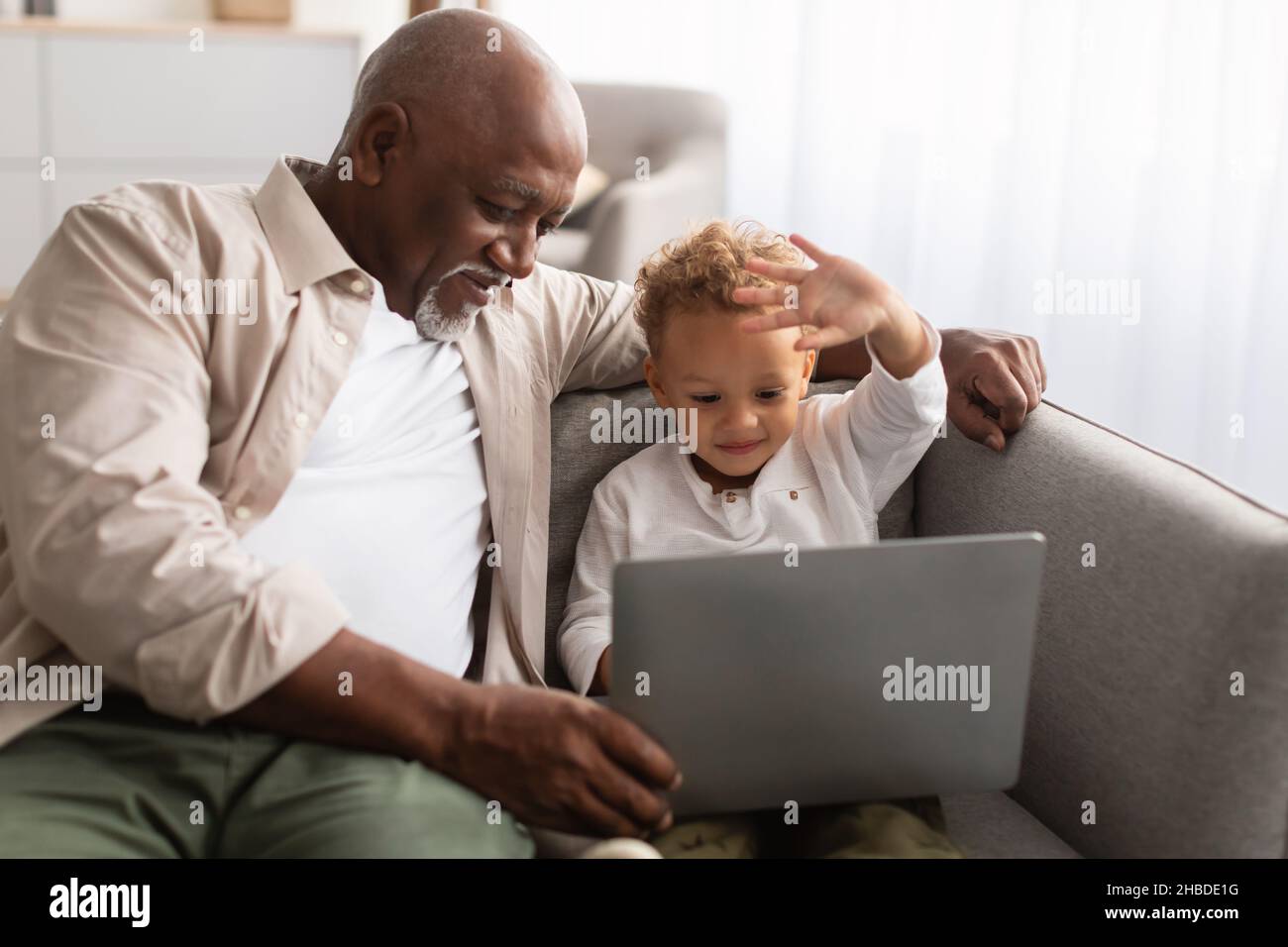African American Grandpa And Grandson Video Calling Via Laptop Indoor ...
