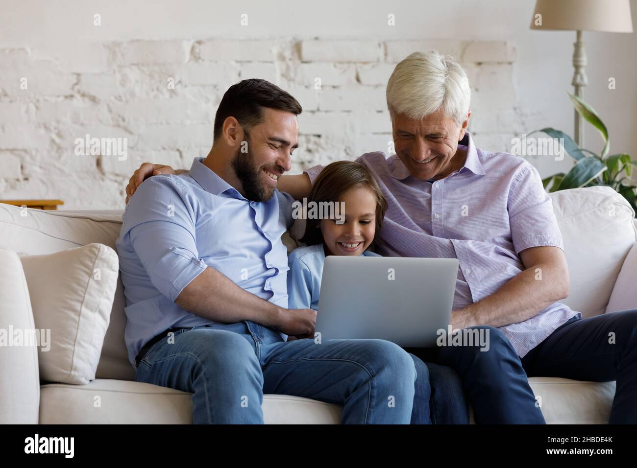 Happy bonding male family using computer apps at home Stock Photo - Alamy