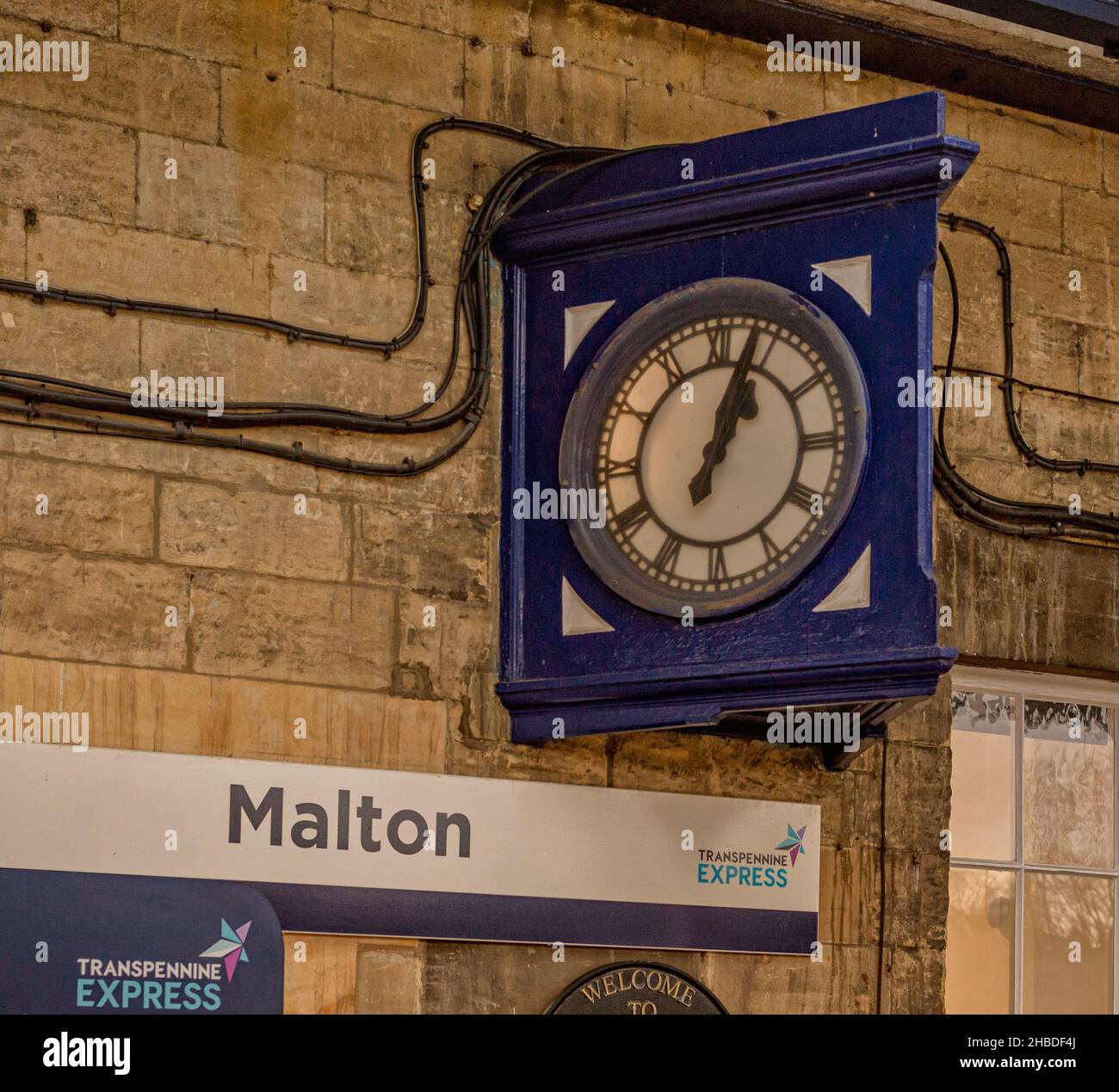 hourA small town and country railway station. An old clock is on a wall ...