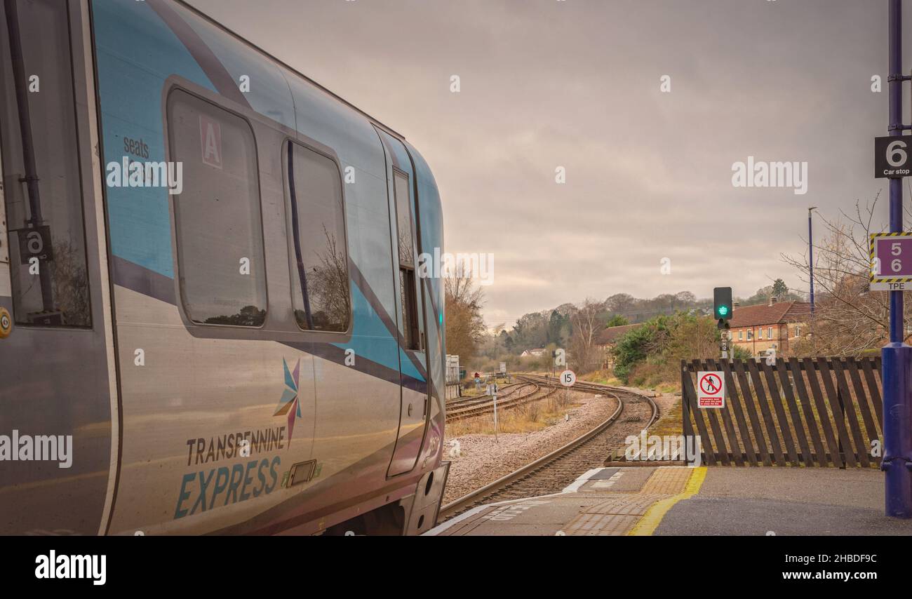 Railway lines curve into the distance as a signal light stands close by ...