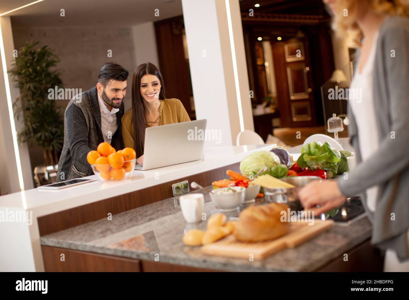 Group of happy young people preparing meal, looking for recipes on the ...